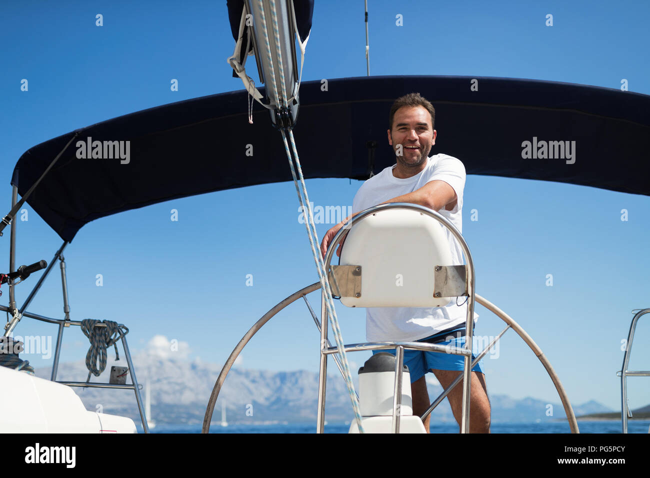 Happy smiling man sailing with his yacht Stock Photo - Alamy