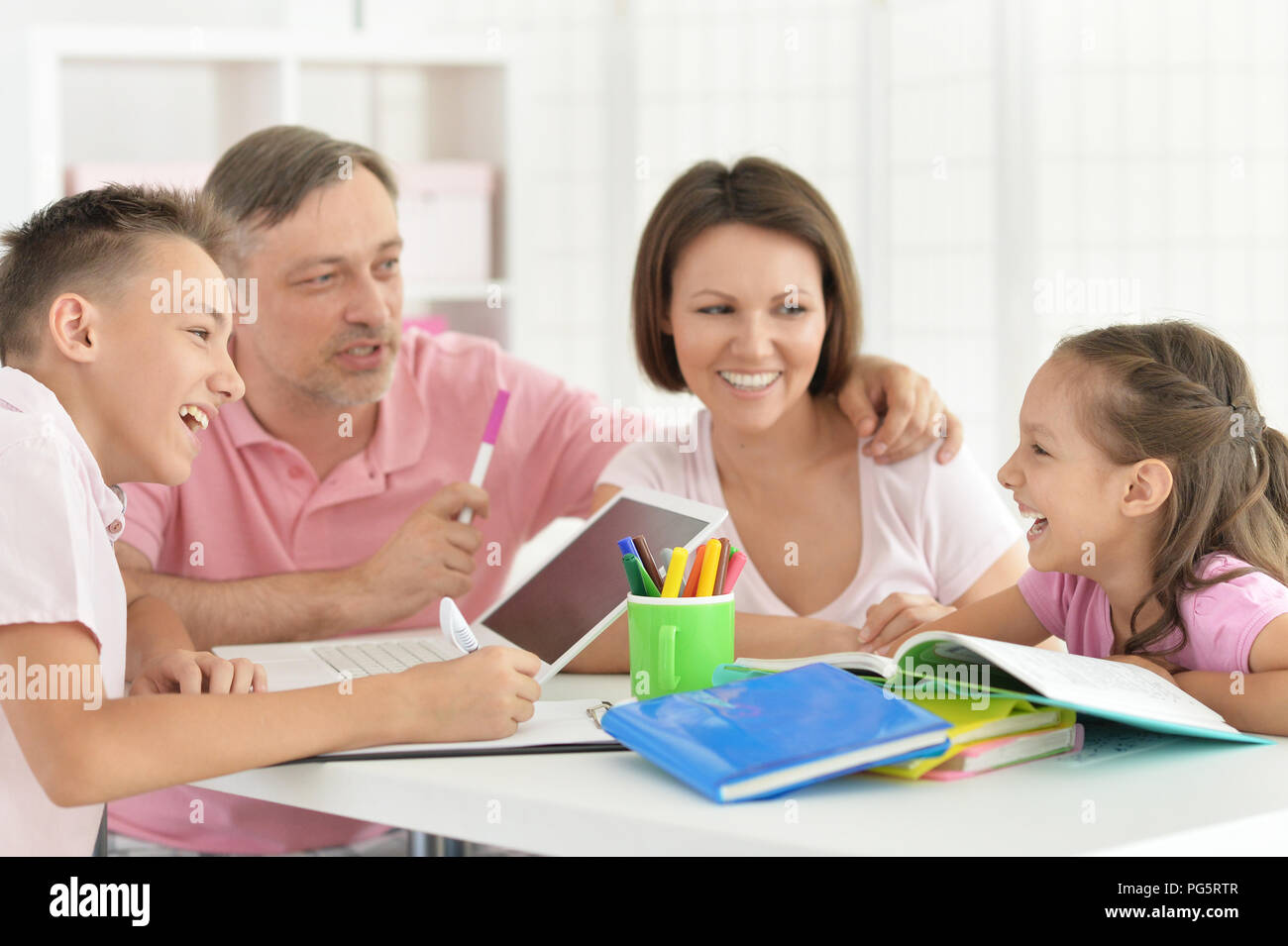 Big happy family doing homework at home Stock Photo - Alamy