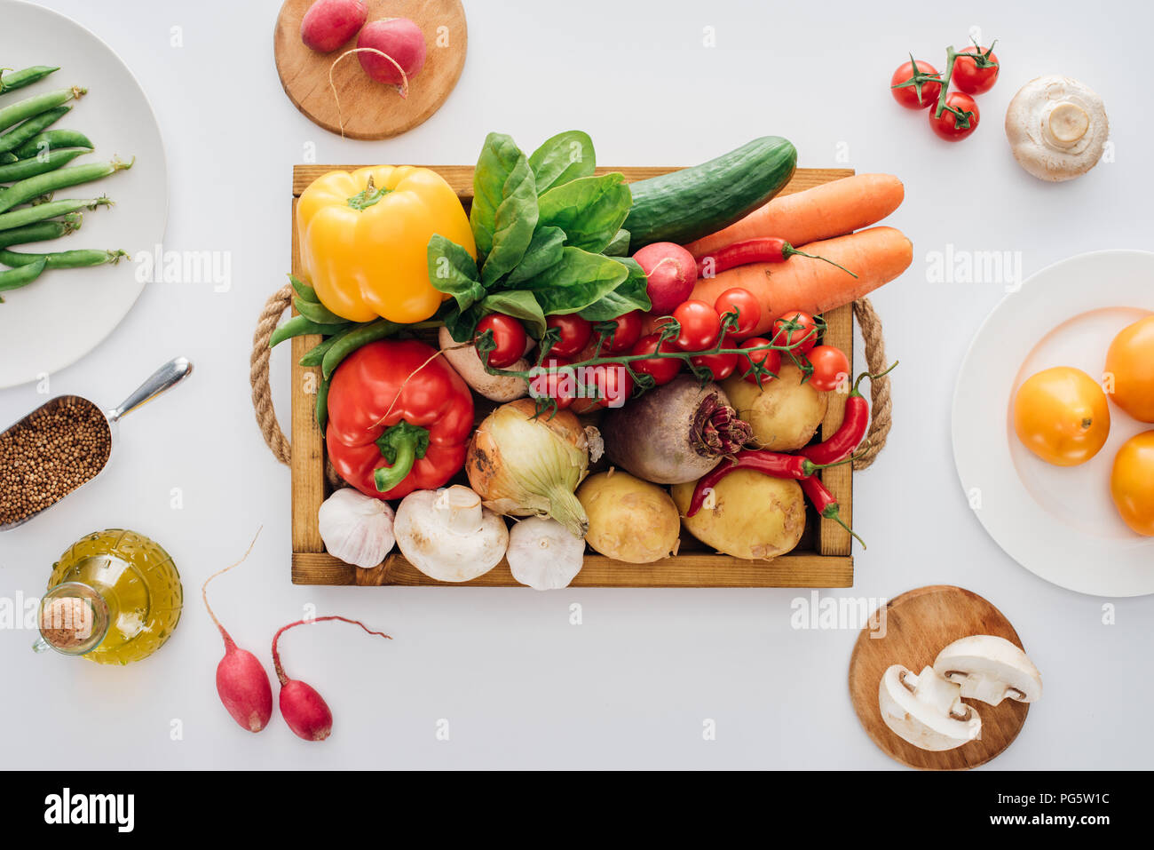 top view of box with fresh raw vegetables and plates isolated on white ...