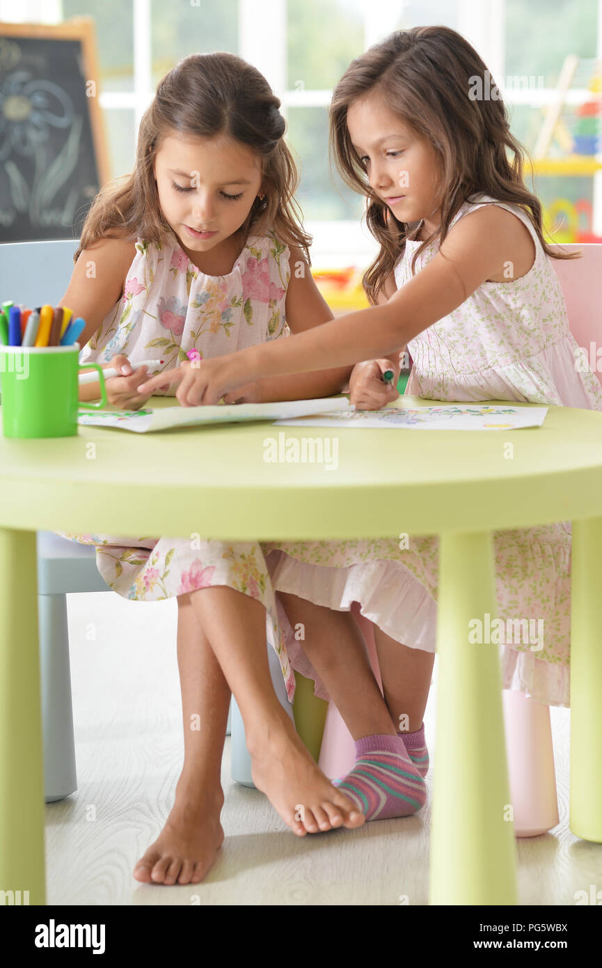 Portrait of two cute little girls drawing together Stock Photo - Alamy