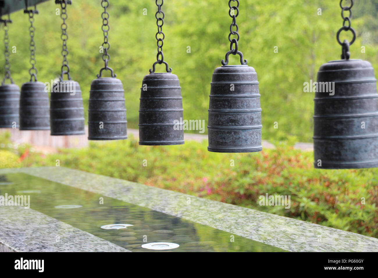A row of zen style hanging bells in Buddhist monastery, with green ...