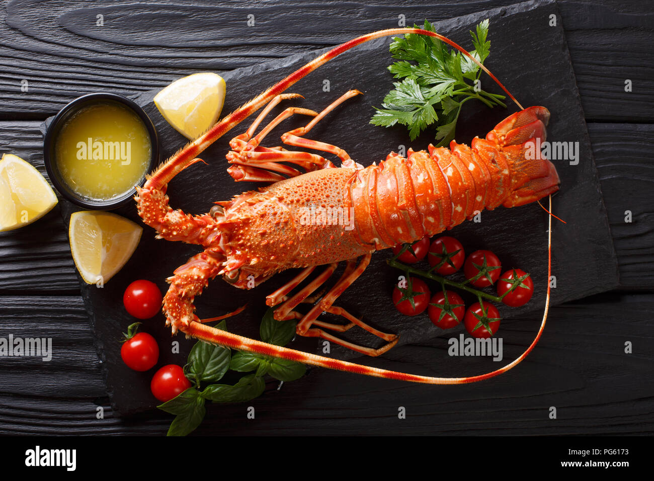 Luxurious boiled spiny lobster surrounded by fresh tomatoes, lemon ...