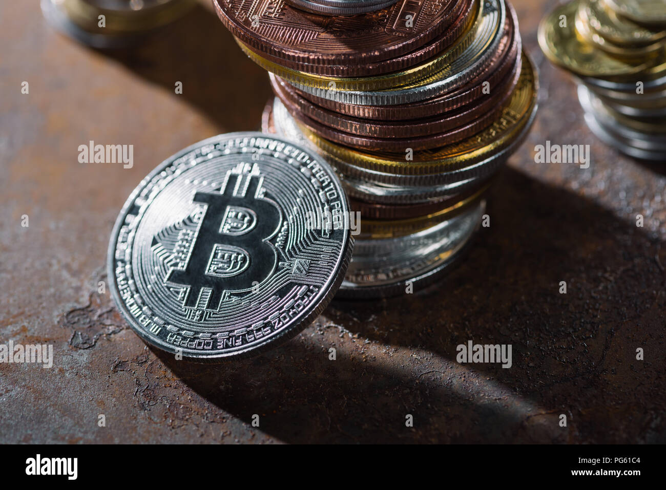 close up view of silver bitcoin leaning on stack of various bitcoins ...