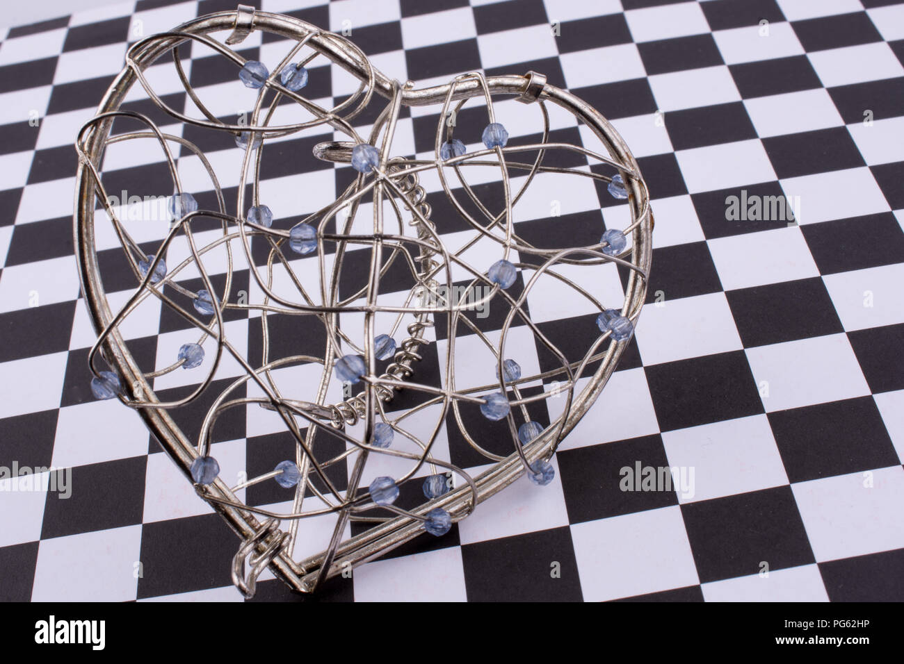 Heart cage on a checked background Stock Photo - Alamy