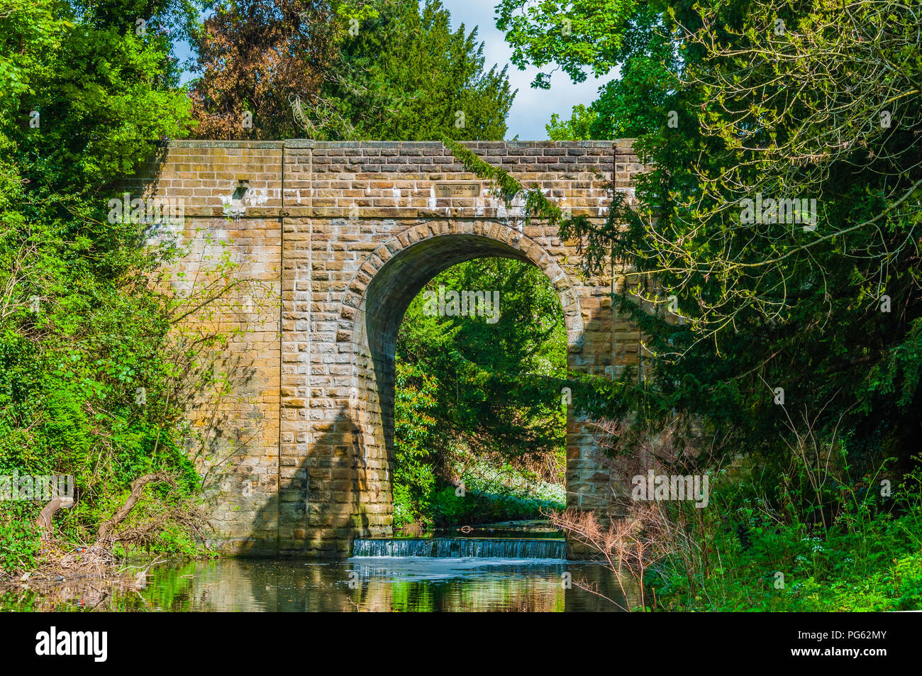 A high stone bridge over a stream and a weir in Jesmond Dene, Newcastle ...
