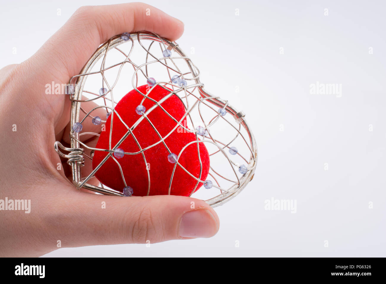 Red heart in a heart shaped cage Stock Photo - Alamy