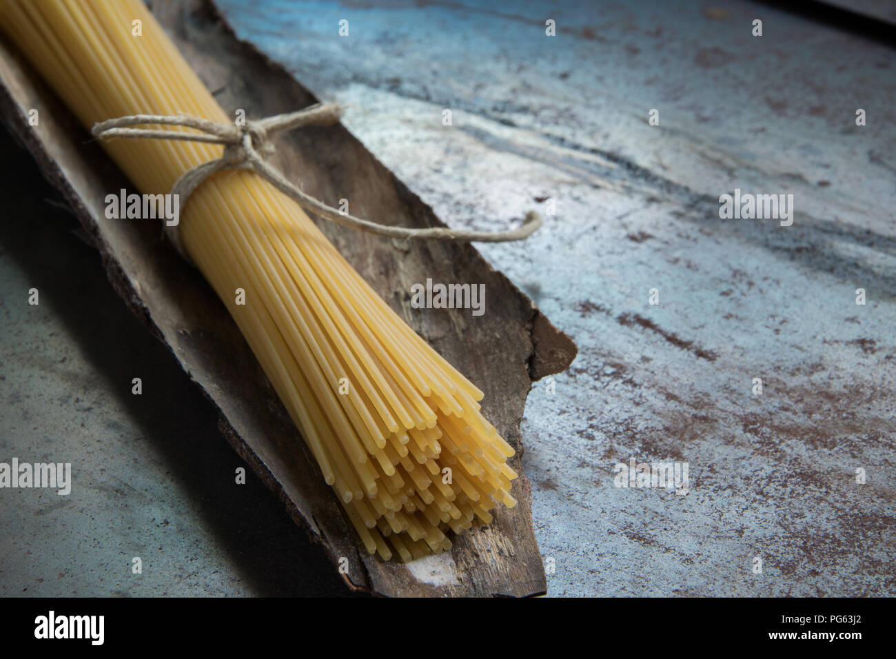 Isolated whole wheat dry spaghetti on rustic background- traditional ...