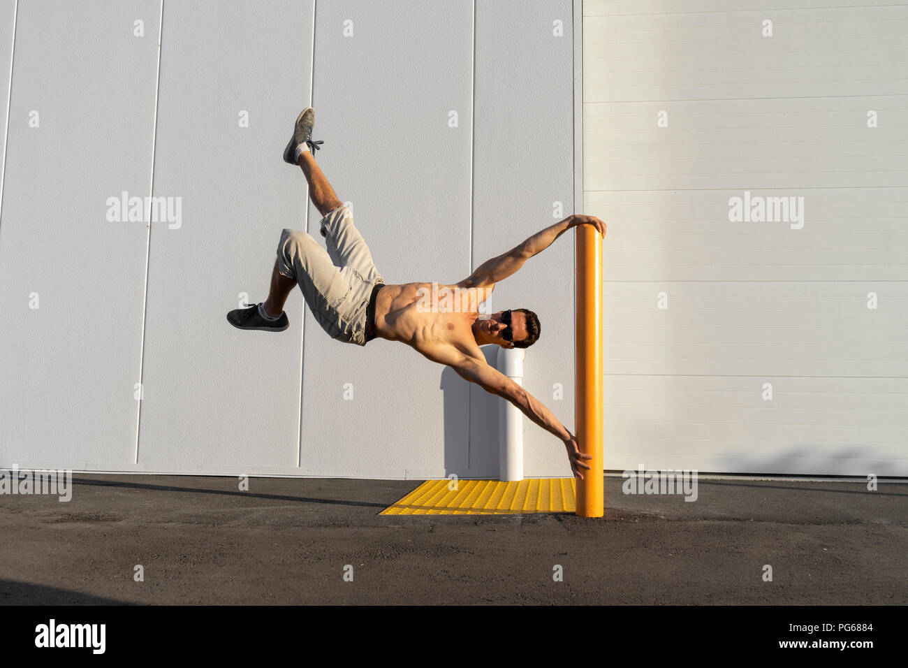 Acrobat training on a pole Stock Photo - Alamy