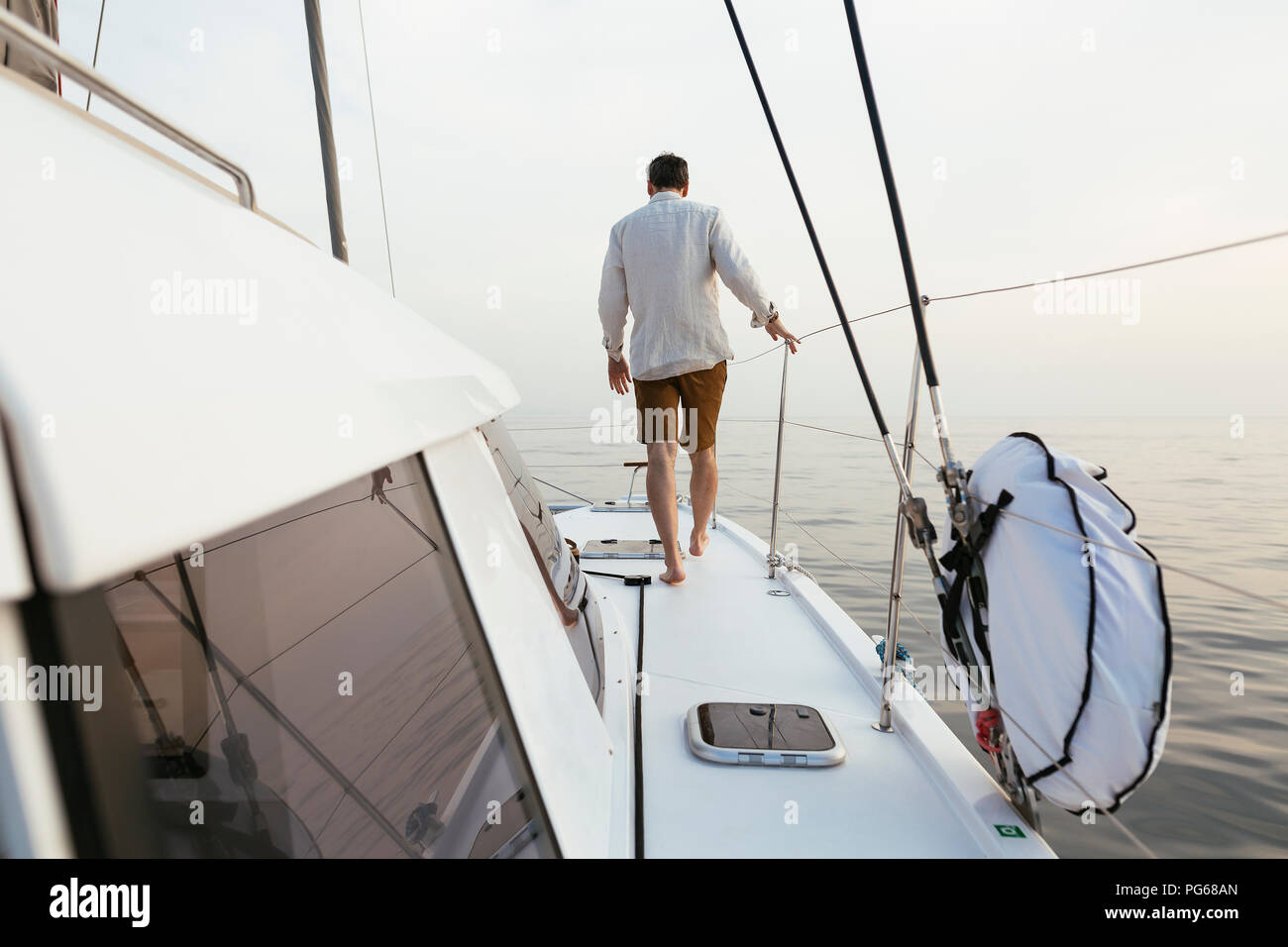 Marure man walking on catamaran, rear view Stock Photo - Alamy