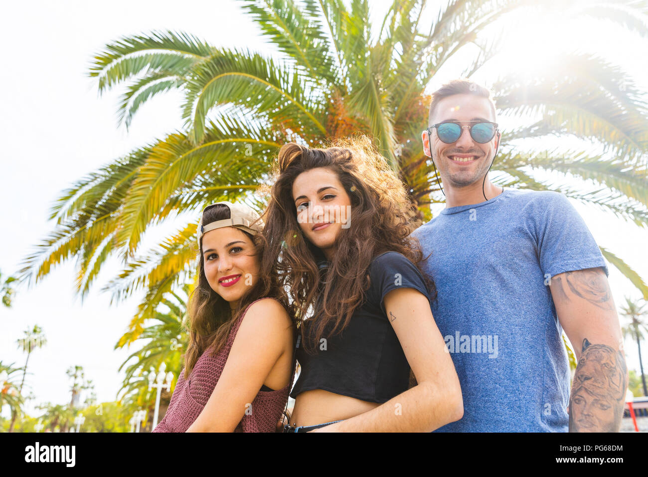 Portrait of smiling friends at a palm tree Stock Photo - Alamy