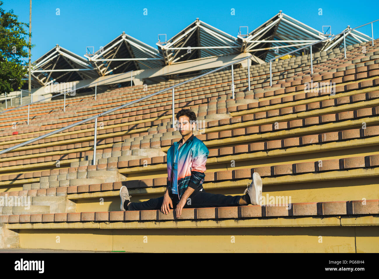 Man doing side splits on stairs of a stadium Stock Photo - Alamy