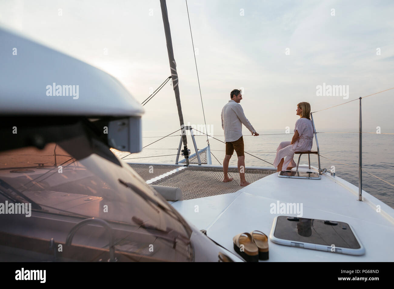 Mature couple standing on catamaran trampoline, enjoying their sailing ...