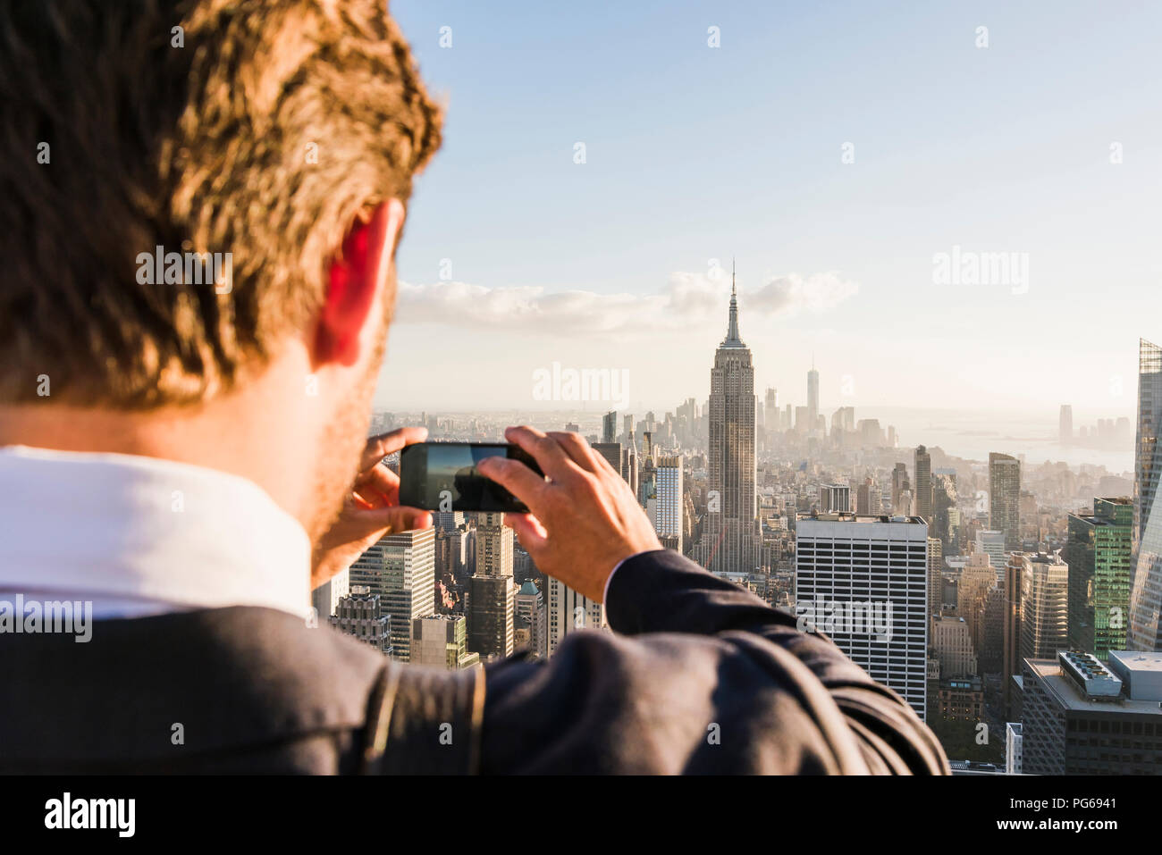 Man taking cell phone picture on rockefeller center observation deck hi ...