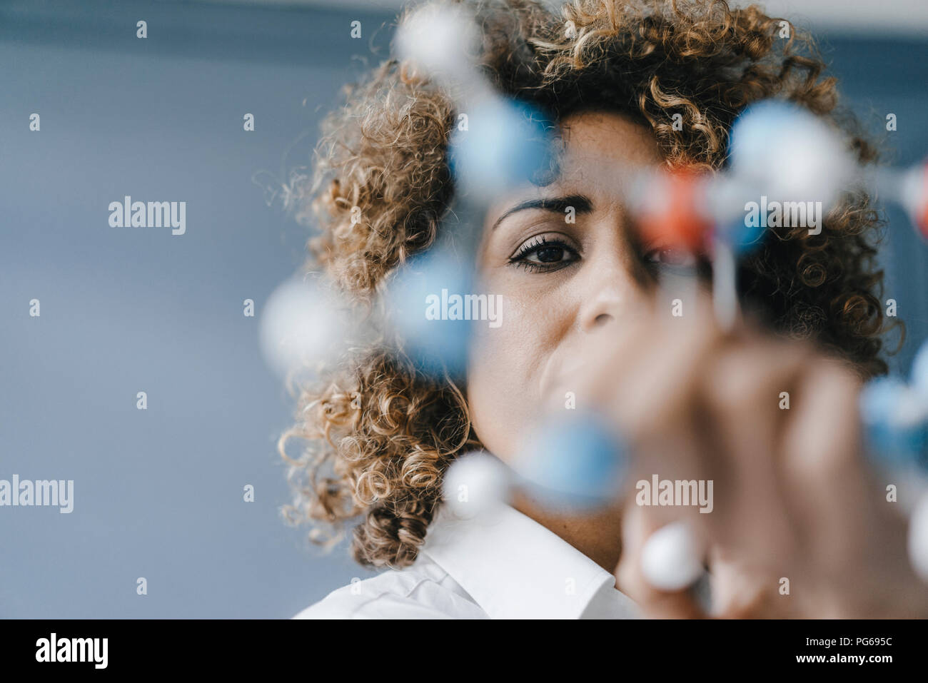 Female scientist looking at molecule model, looking for solutions Stock ...