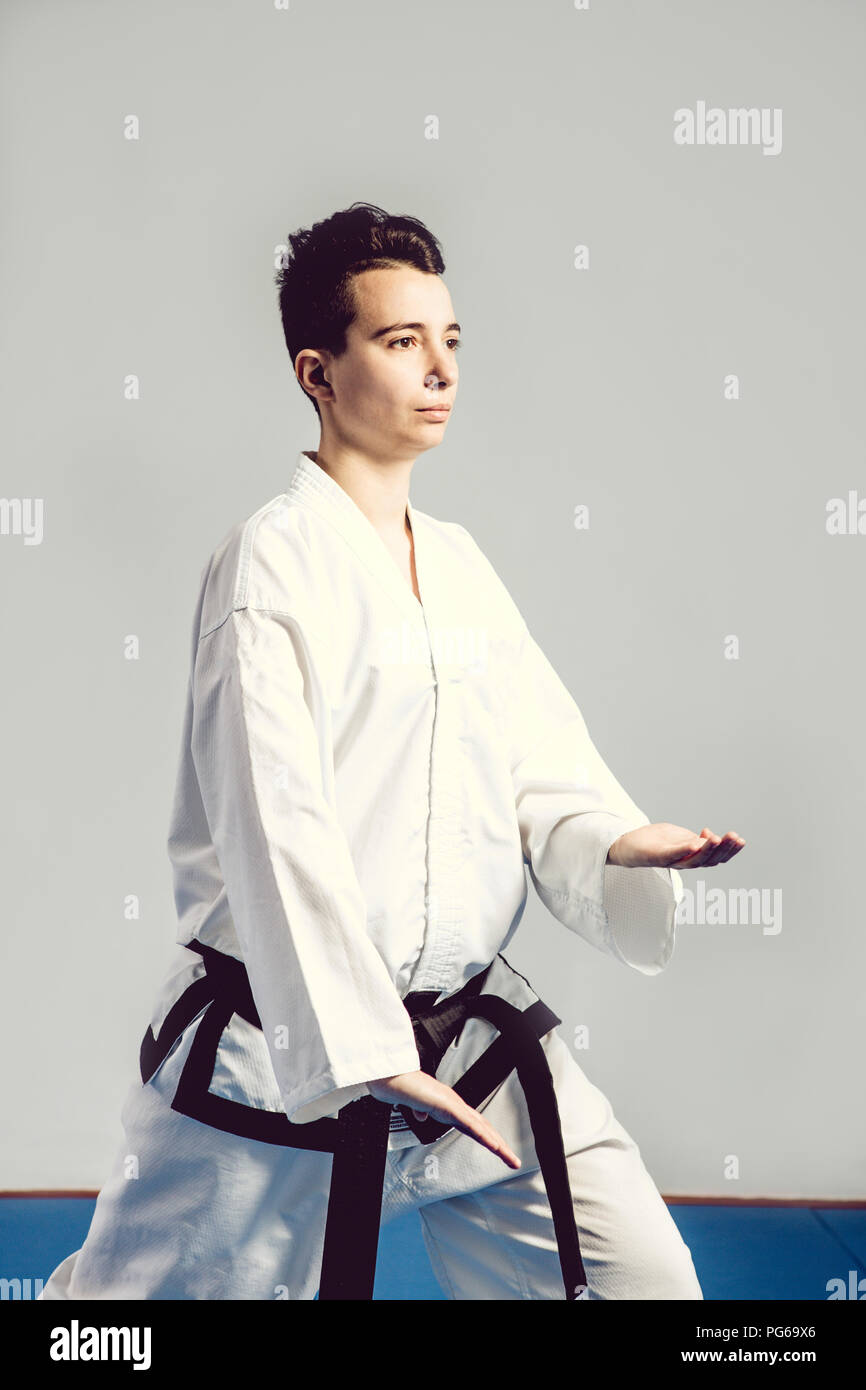 girl in karate suit kimono in studio at grey background. Female child ...