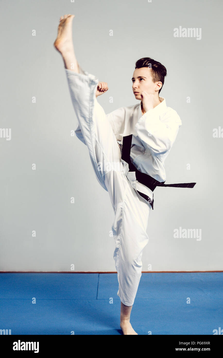 girl in karate suit kimono in studio at grey background. Female child ...