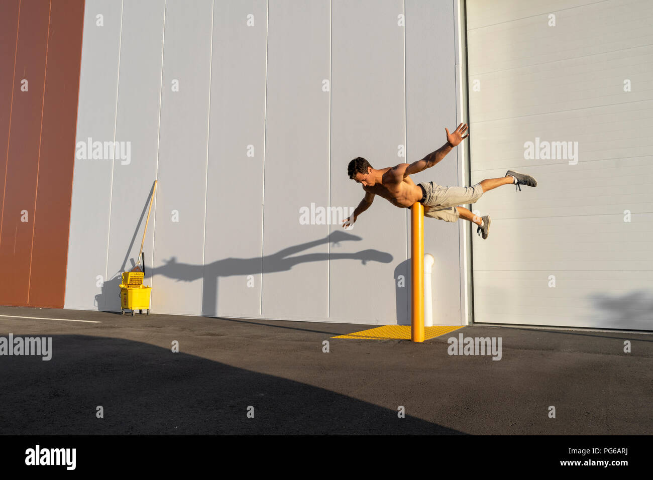 Acrobat training on a pole Stock Photo - Alamy