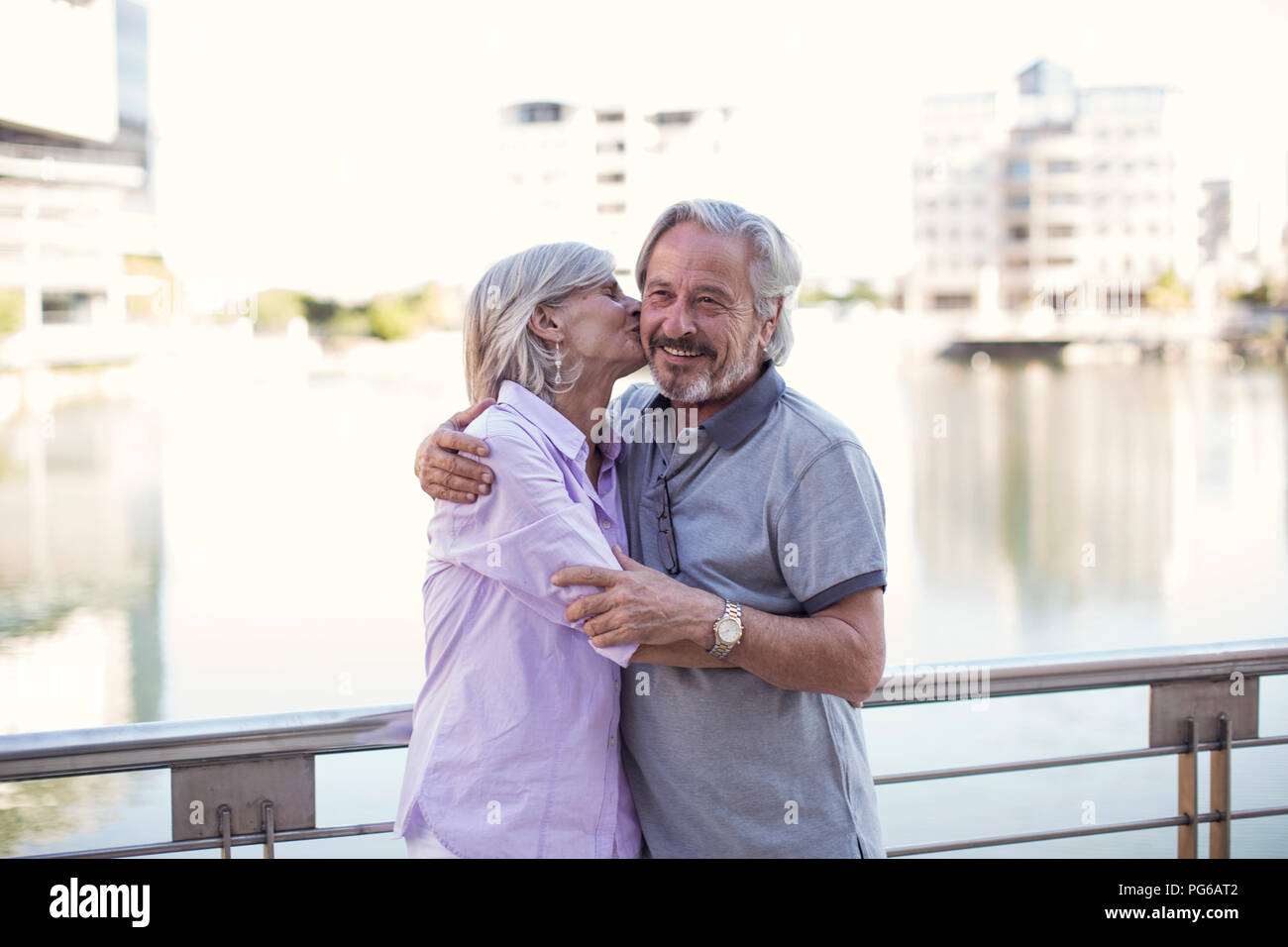 Senior couple taking a city break, kissing and embracing Stock Photo ...