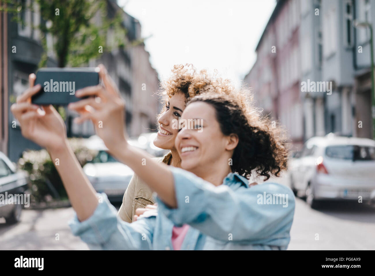Best friends taking selfies with a smartphone in the city Stock Photo ...