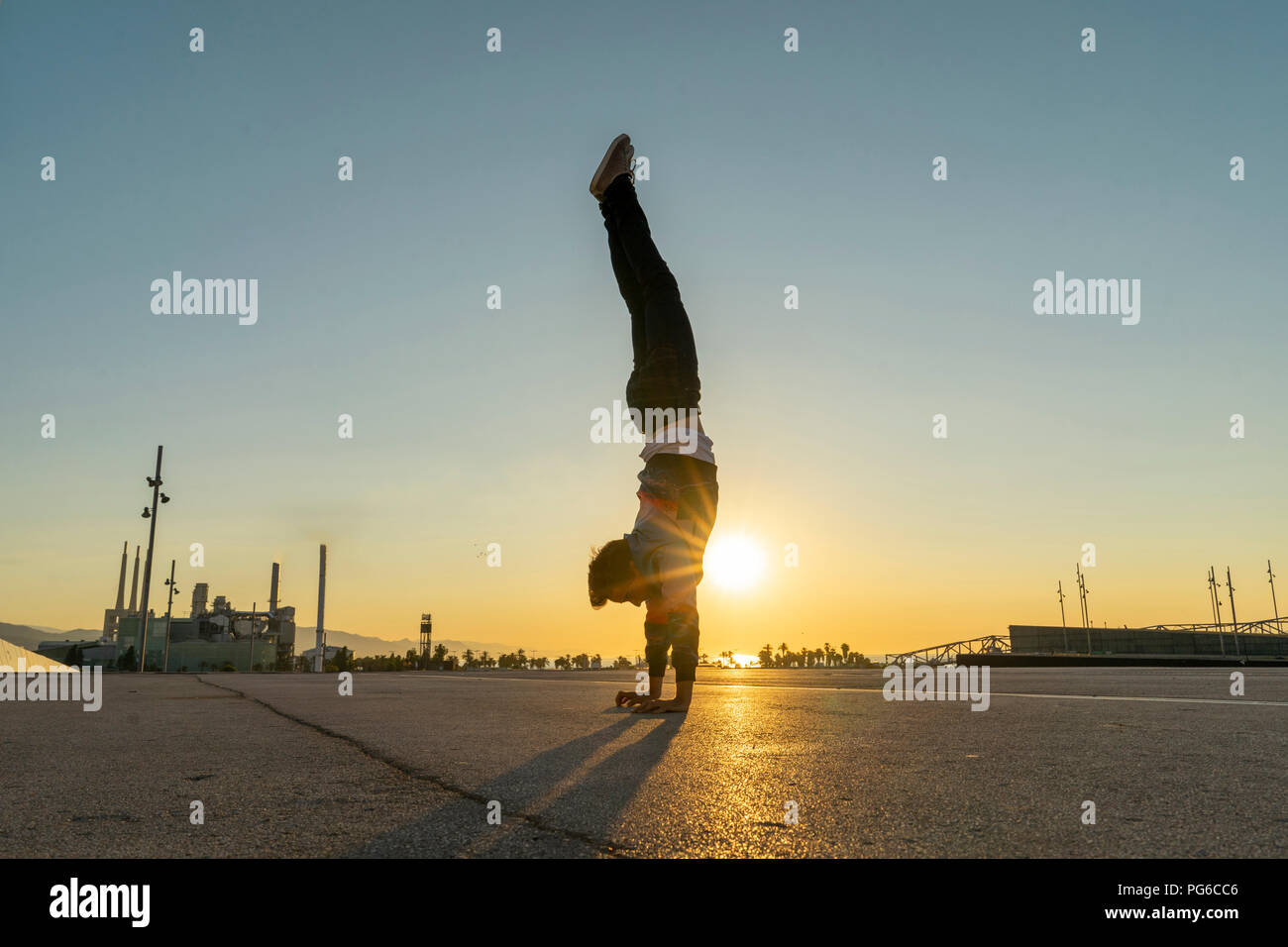 Acrobat doing handstand in the city at sunrise Stock Photo - Alamy