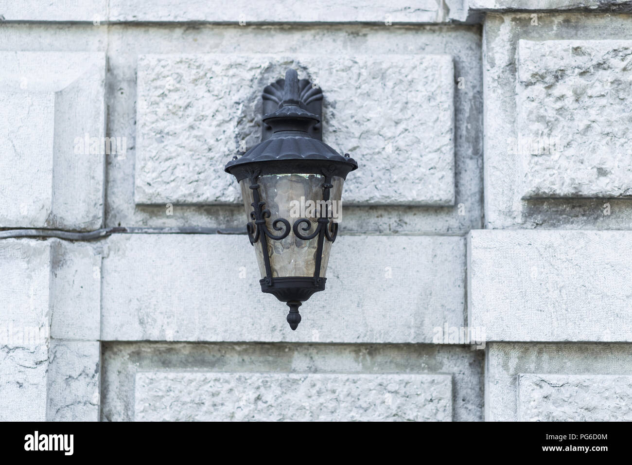 Old black iron lamp on stone wall of middle ages castle Stock Photo - Alamy