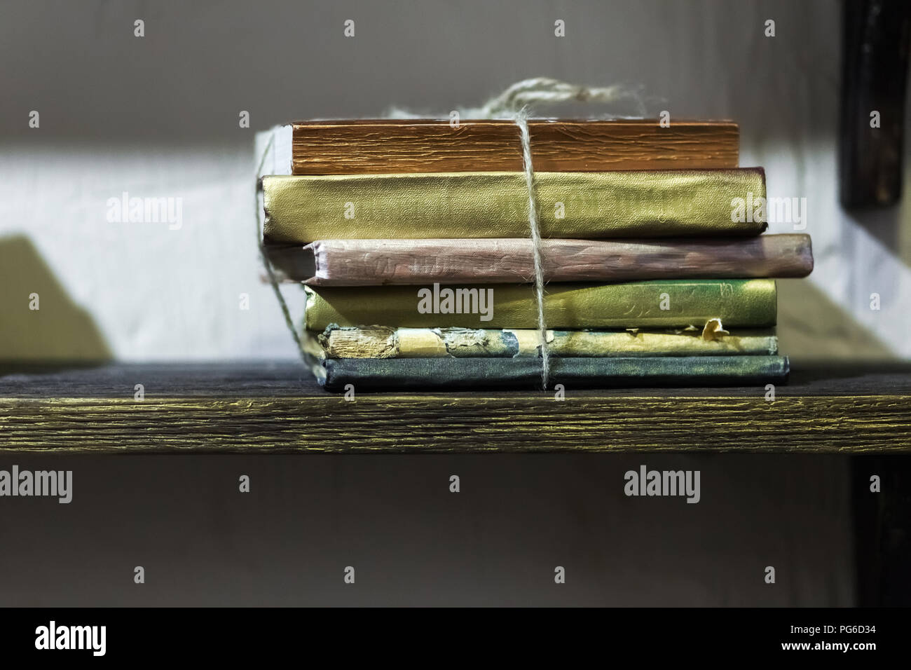 Stack of old books with golden covers on the shelf Stock Photo - Alamy