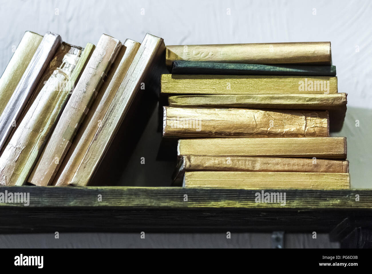 Stack of old books with golden covers on the shelf Stock Photo - Alamy