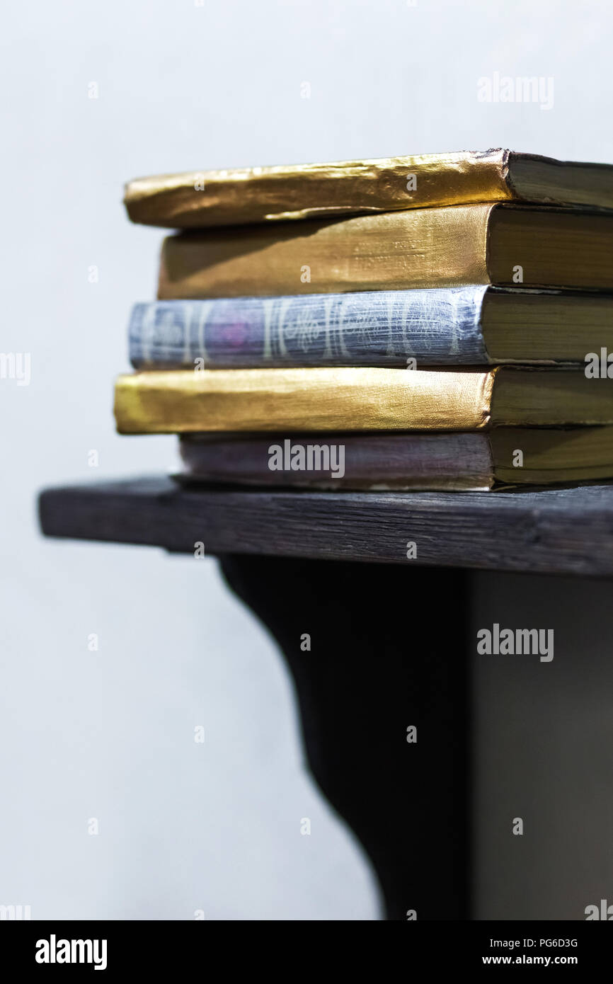 Stack of old books with golden covers on the shelf Stock Photo - Alamy