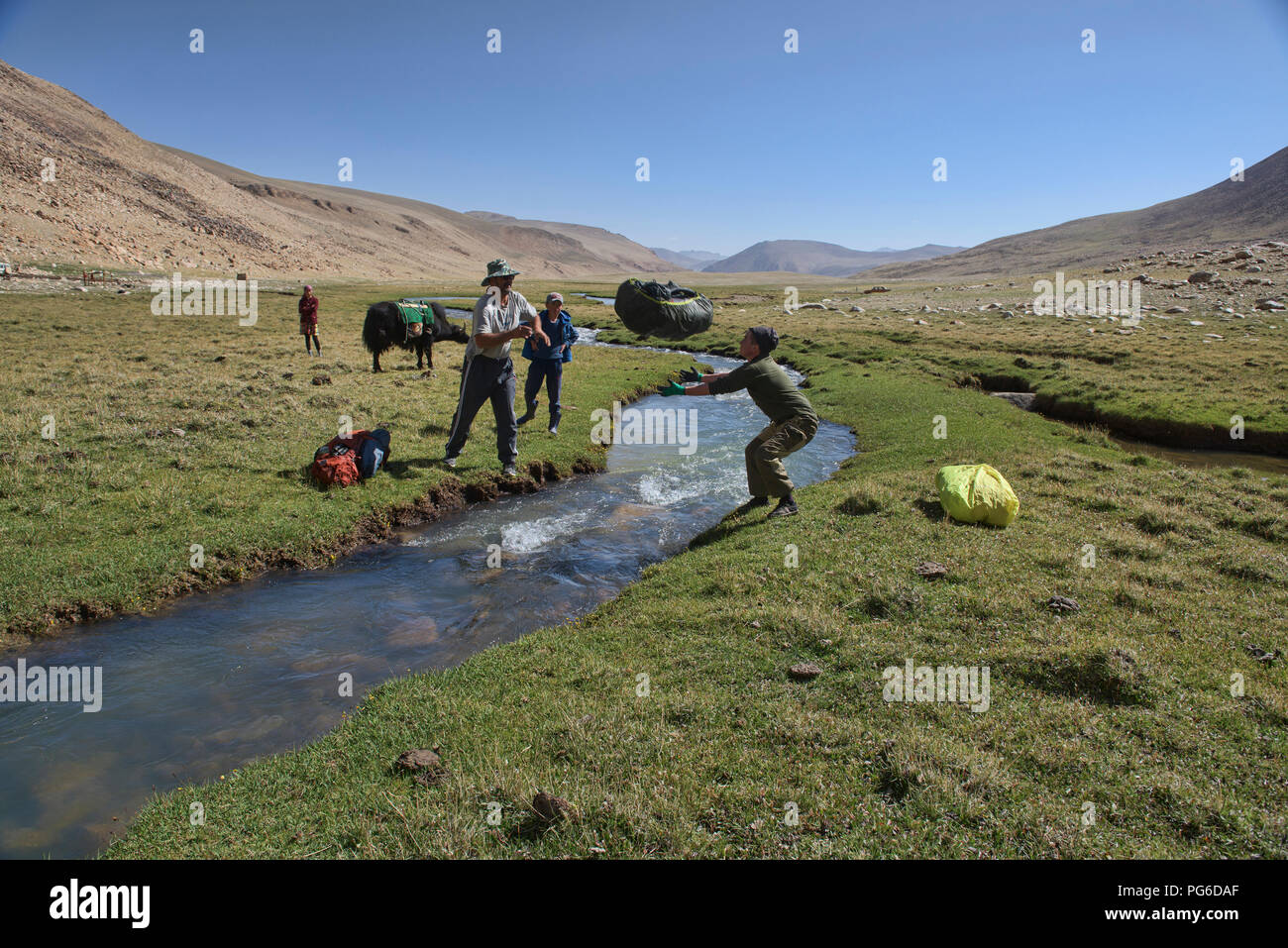 Getting packs across the river while trekking to Lake Zorkul ...