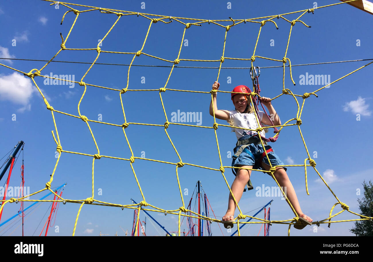 active way of life - a little girl is going through a rope in a town ...