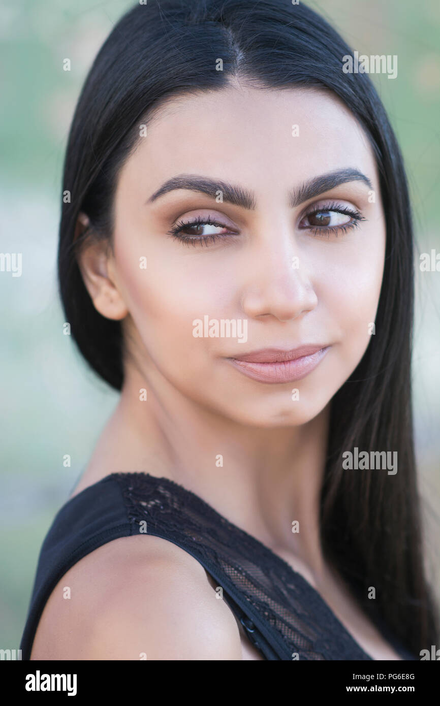 Beautiful young woman looking over shoulder Stock Photo - Alamy