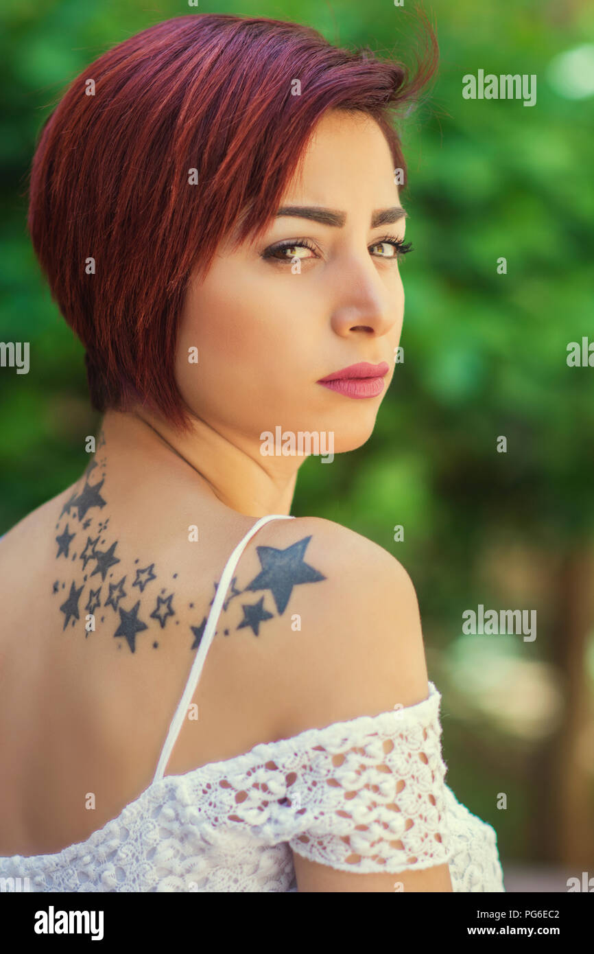 Beautiful woman looking over shoulder Stock Photo - Alamy