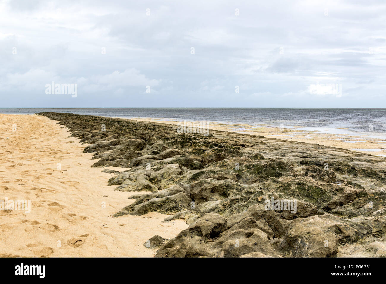 Tropical beach covered with line of rock Stock Photo - Alamy