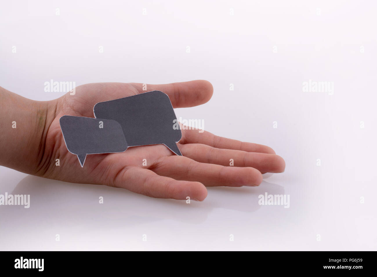 Hand holding dialogue boxes on a white background Stock Photo - Alamy