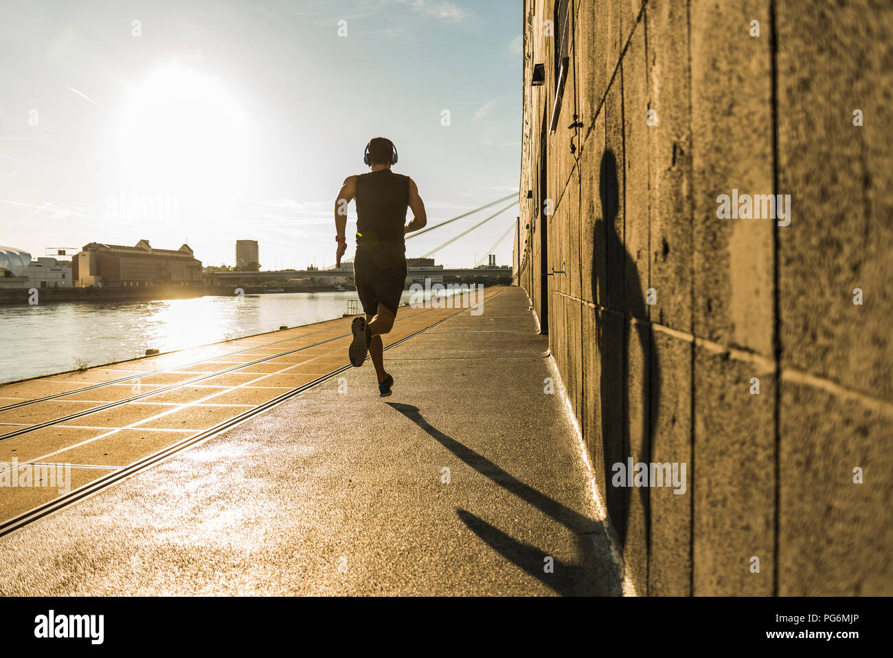 Young athlete jogging in the city at the river Stock Photo - Alamy