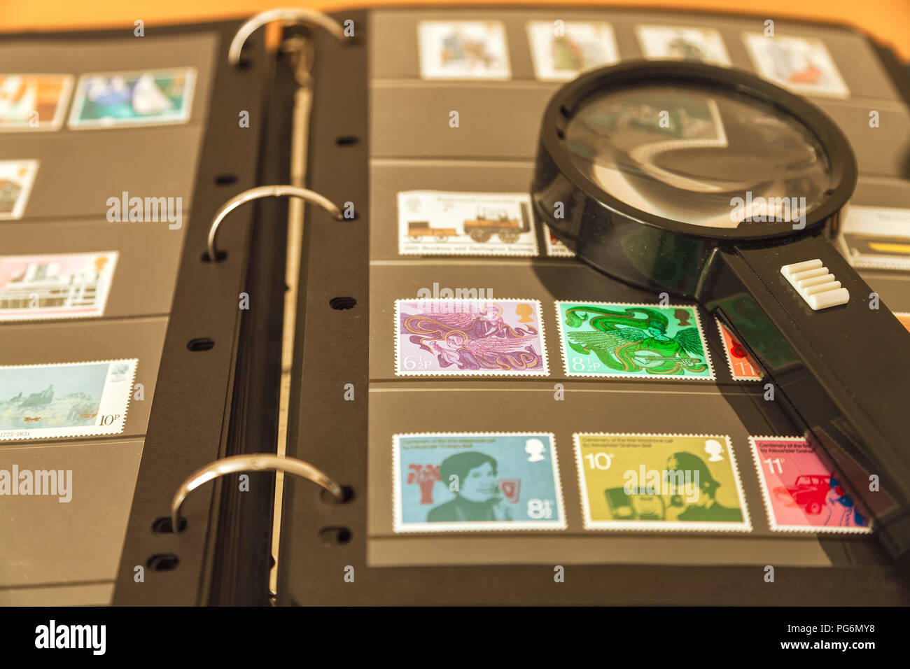 stamp album with magnifying glass Stock Photo - Alamy