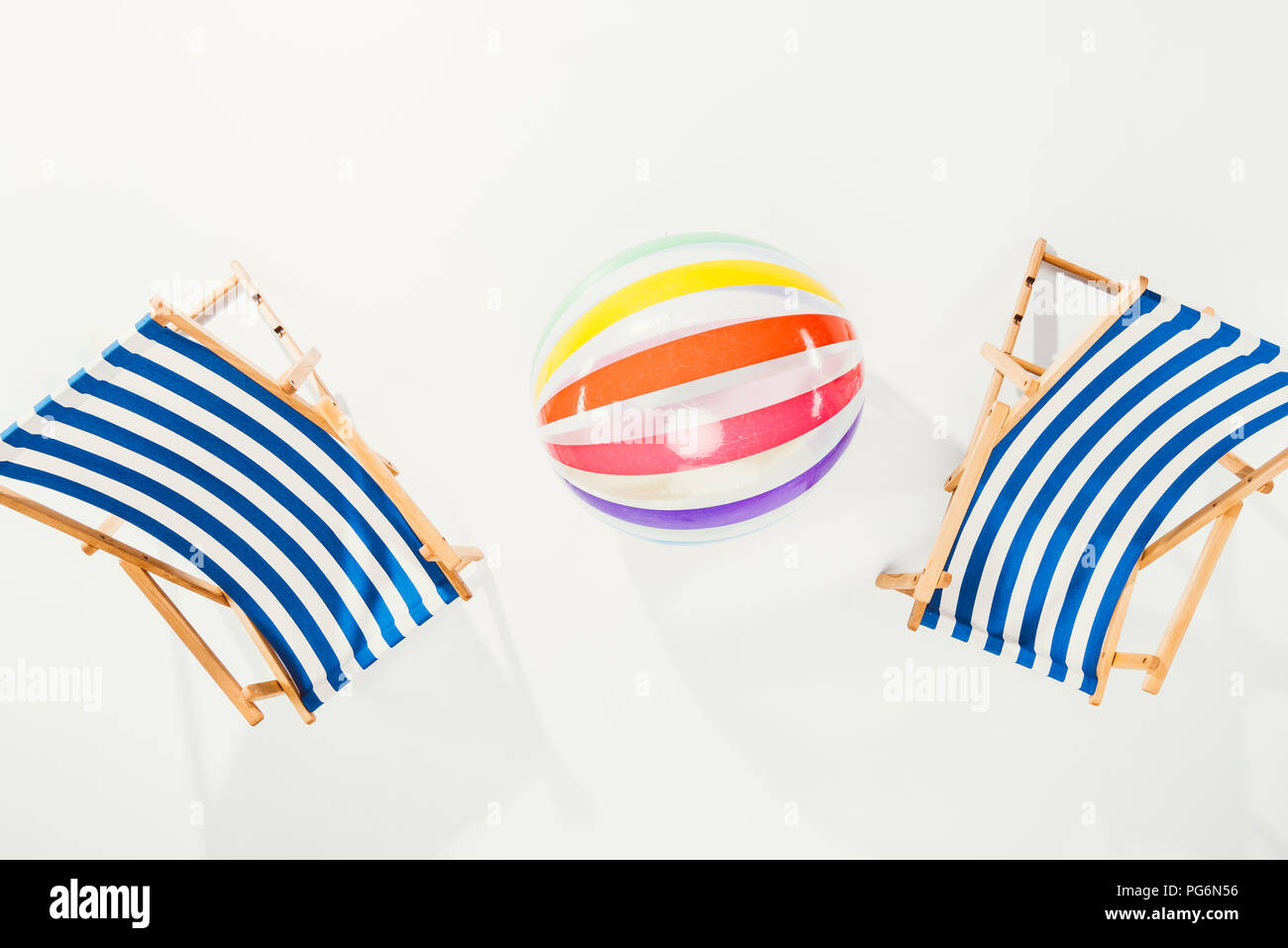 top view of striped beach chairs and inflatable ball isolated on white ...