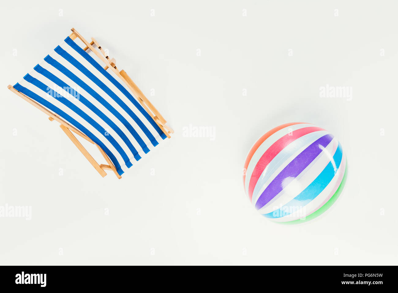 top view of striped beach chair and inflatable beach ball isolated on ...