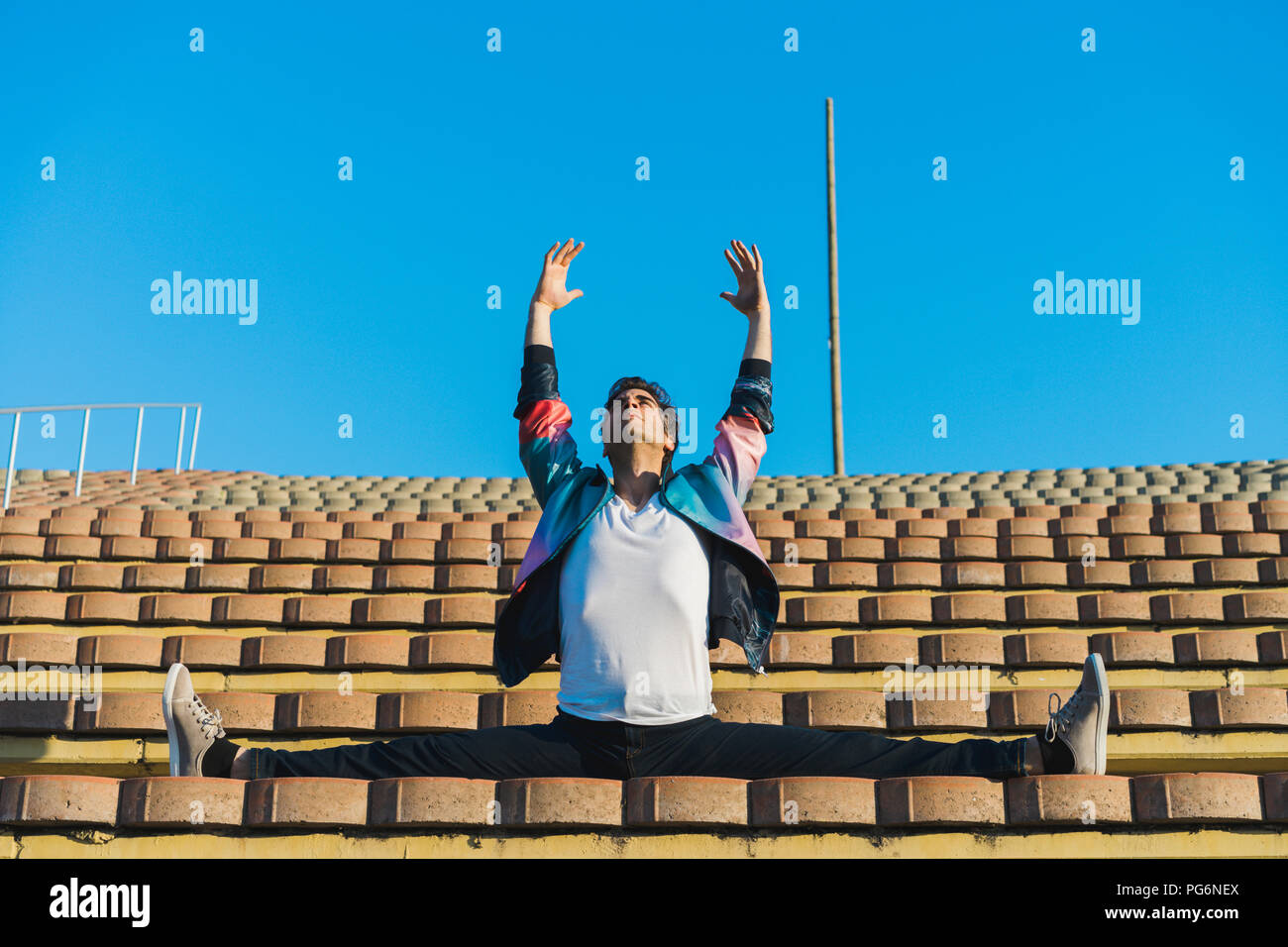Man doing side splits on stairs of a stadium Stock Photo - Alamy