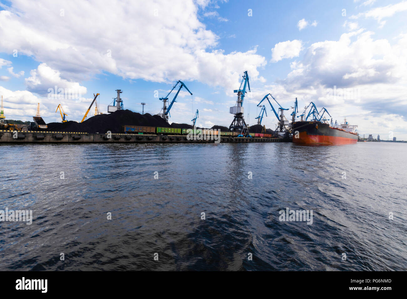Large red cargo ship loading with a coal in the port, terminal, crane ...
