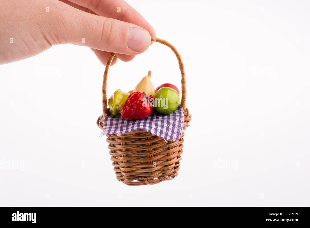 Hand holding a fruit basket on a white background Stock Photo - Alamy