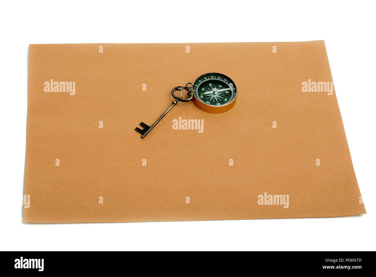 key and compass on a sheet of colored plain paper with a white ...