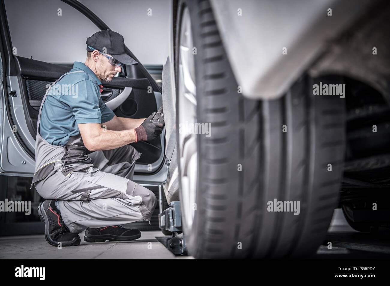 Used Car Under Maintenance. Caucasian Car Mechanic Looking For ...