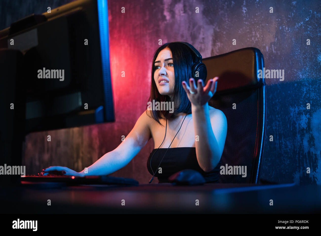 Terrified gamer plays games on your computer. An emotional young woman ...