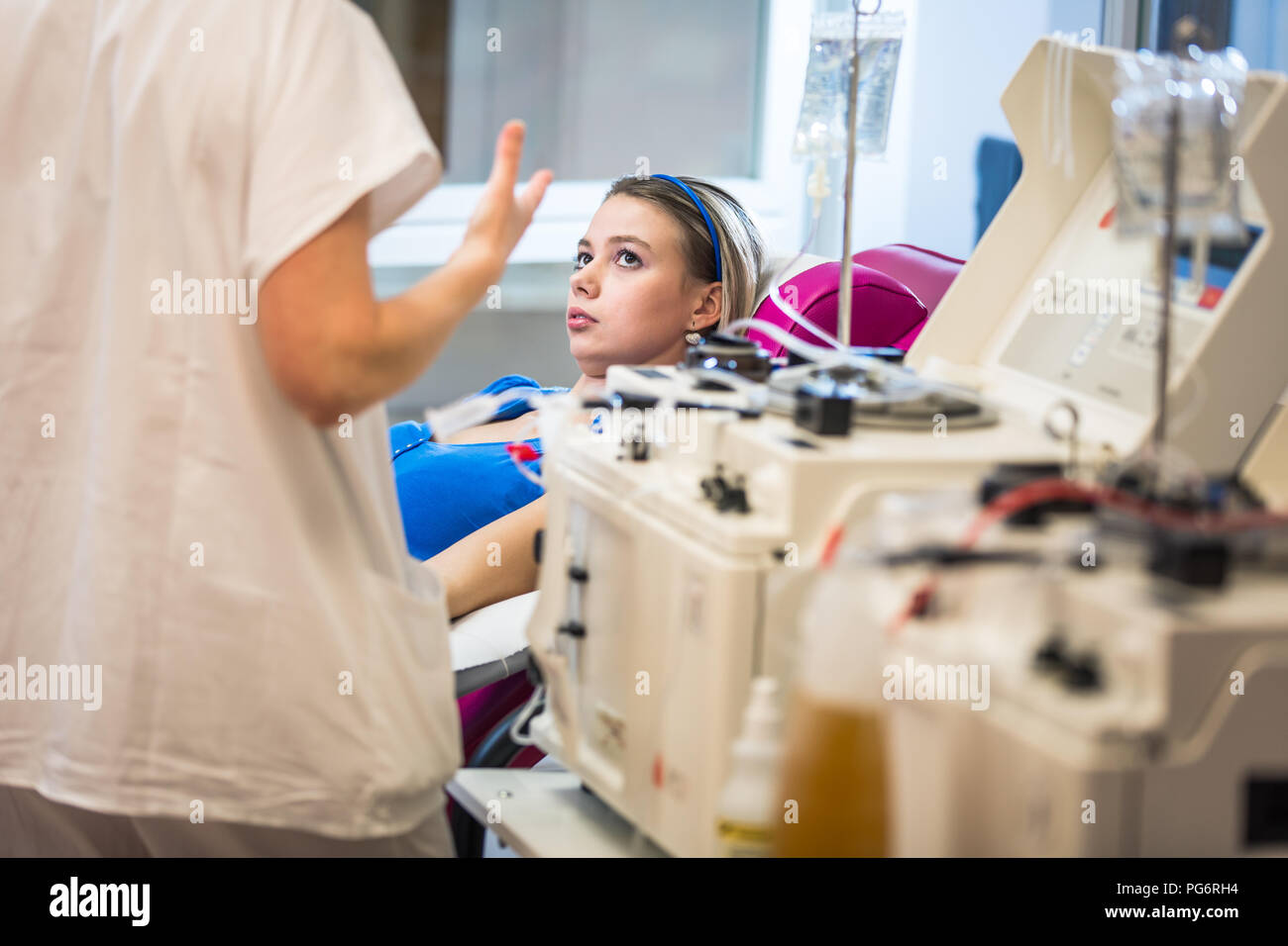 Young woman giving blood in a modern hospital Stock Photo - Alamy