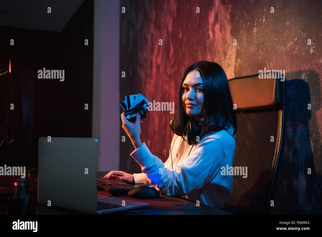young teenager hacker girl in hoodie holding credit card violating ...