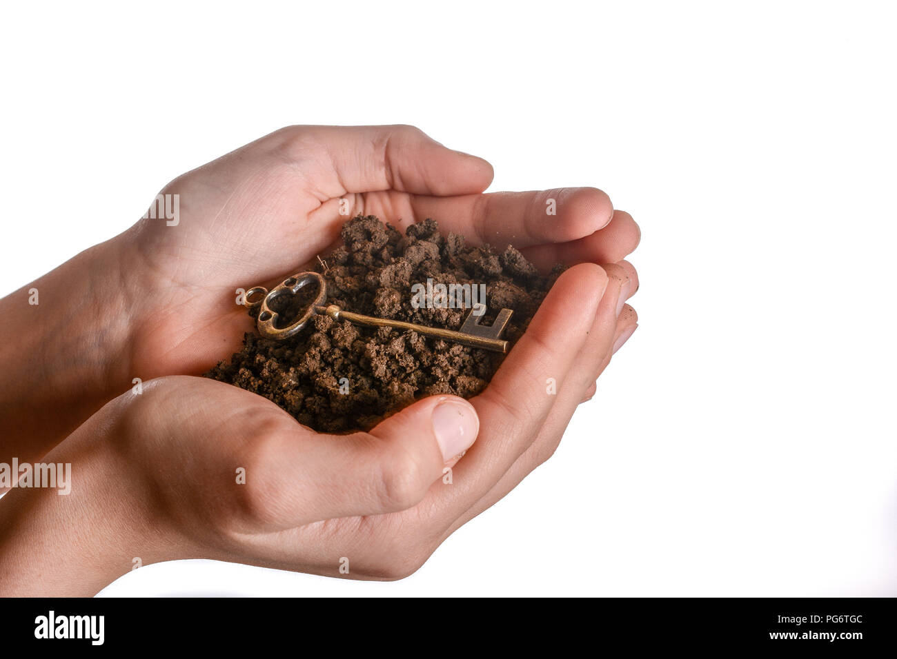 Golden key in handful soil in hand on an isolated background Stock ...