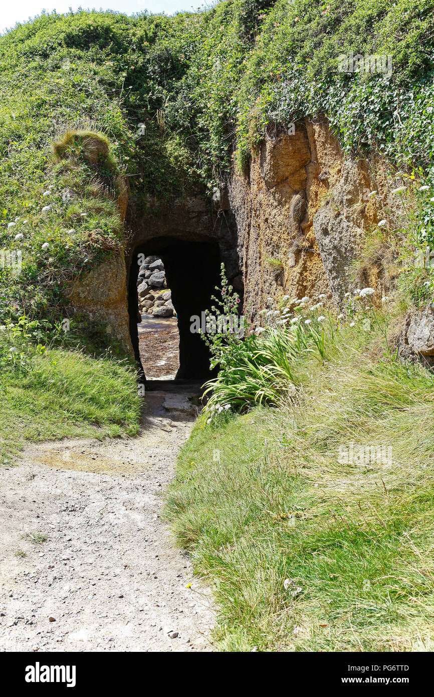 A gap in the rocks or a rock arch at Porthgwarra, Cornwall, South West ...