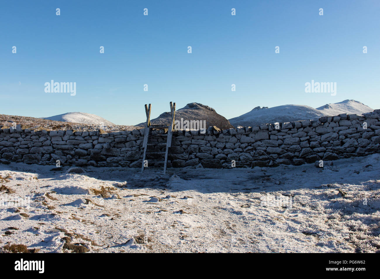 Snow encrusted Mourne Wall and stile leading to heart of Mourne ...