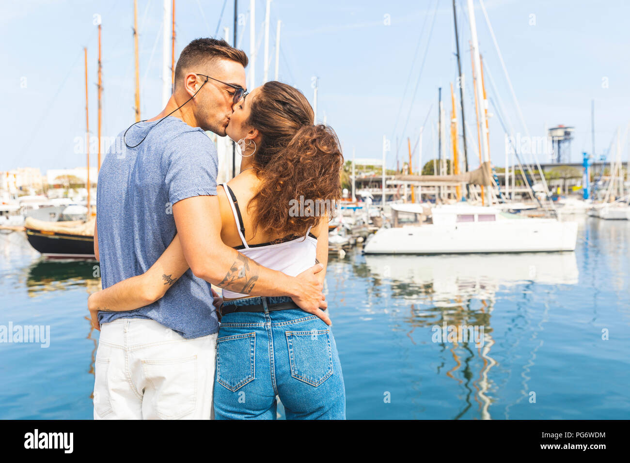 Back view of a young couple kissing at marina Stock Photo - Alamy